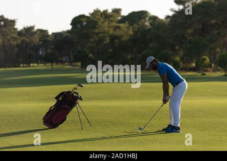 golfer hitting long shot with driver on course at beautiful sunset duo ...