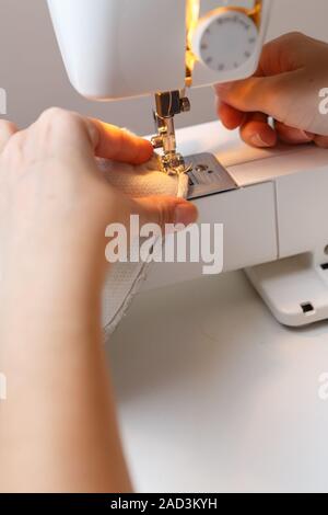 seamstress work on the sewing machine. young blonde woman working on a ...