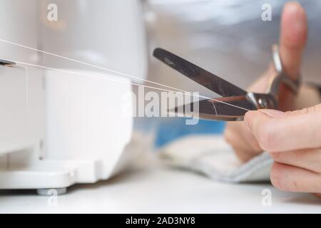 seamstress cuts the thread with sewing scissors Stock Photo - Alamy