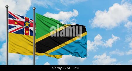 New Zealand and Tanzania flag waving in the wind against white cloudy ...