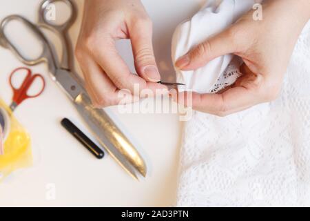 Woman unpick fabric on table near sewing machine Stock Photo - Alamy