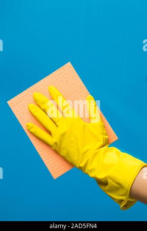 hand wipes glass of home window in urban apartment house by blue rag ...