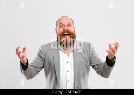 White ginger man with beard screaming while making winner gesture ...