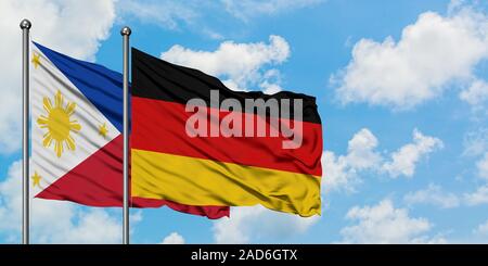 Germany and Philippines flag waving in the wind against white cloudy ...
