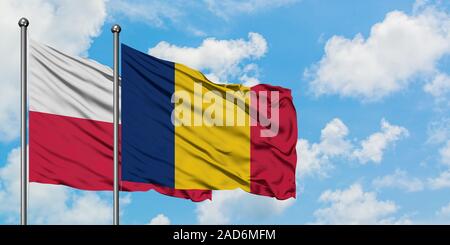 Chad and Poland flag waving in the wind against white cloudy blue sky ...