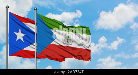 Puerto Rico and Guinea flag waving in the wind against white cloudy ...