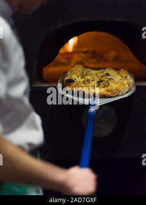 chef removing hot pizza from stove Stock Photo - Alamy