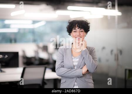 Portrait of successful female software developer with a curly hairstyle ...