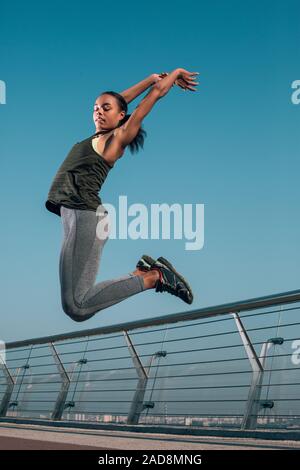 young woman jumping high at the bridge Stock Photo - Alamy