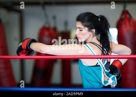 Determined muscular boxer hanging on ropes Stock Photo - Alamy