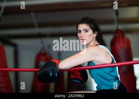 Determined muscular boxer hanging on ropes Stock Photo - Alamy