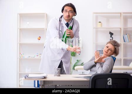 The female alcoholic visiting young male doctor Stock Photo - Alamy