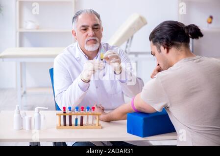 Young handsome man during blood test sampling procedure Stock Photo - Alamy