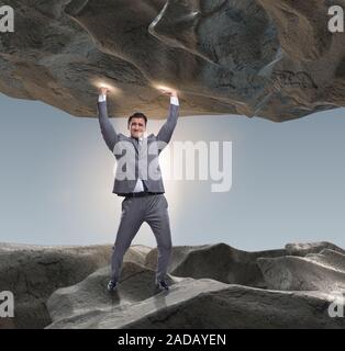 Businessman supporting stone under pressure Stock Photo - Alamy