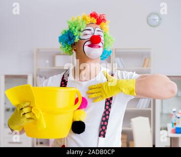 Funny clown doing cleaning at home Stock Photo - Alamy