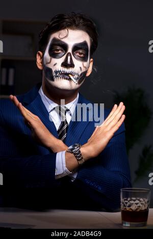 Businessman with scary face mask working late in office Stock Photo - Alamy