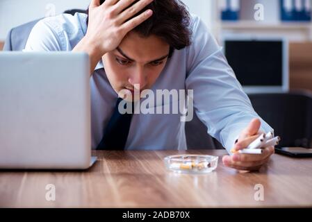 The male employee smoking cigarettes at workplace Stock Photo - Alamy