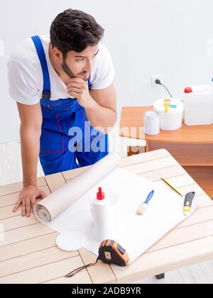 Worker working on wallpaper during refurbishment Stock Photo - Alamy