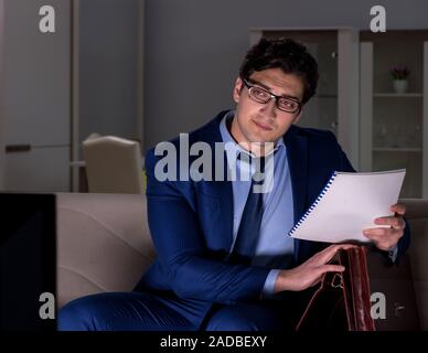 Businessman watching tv at night late Stock Photo - Alamy