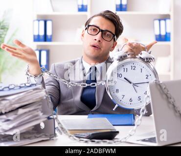 The busy employee chained to his office desk Stock Photo - Alamy