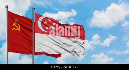 Singapore and Soviet Union flag waving in the wind against white cloudy ...