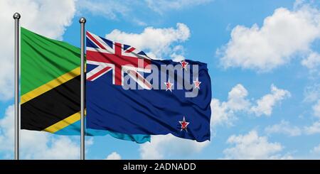 New Zealand and Tanzania flag waving in the wind against white cloudy ...
