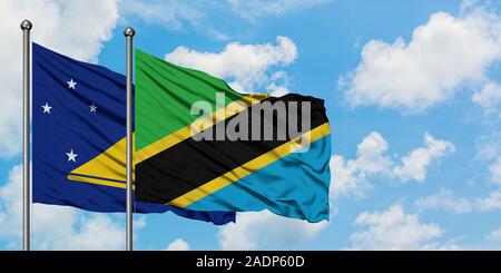 New Zealand and Tanzania flag waving in the wind against white cloudy ...