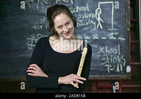 Female teacher holding a ruler in a classroom Stock Photo - Alamy