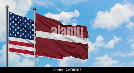 Latvia and United States flag waving in the wind against white cloudy ...