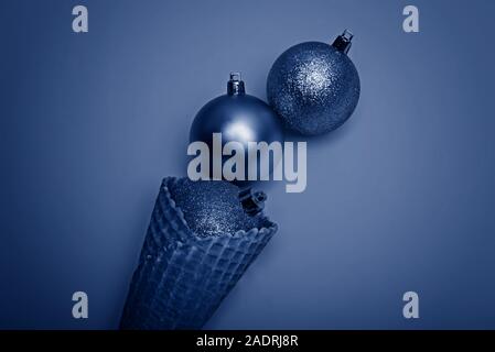 Color of the year 2020: Blue. Golden christmas balls in ice cream ...