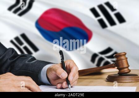 South Korea flag with judge mallet and handcuffs in dark room. Concept ...