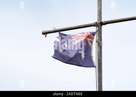 A torn and shredded Australian blue ensign flag hanging from a ...