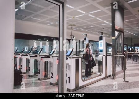 Air travelers pass through automated passport border control gates ...