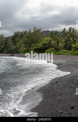 Black sand beach in Hana Bay on the northeast coast of Maui, in the ...