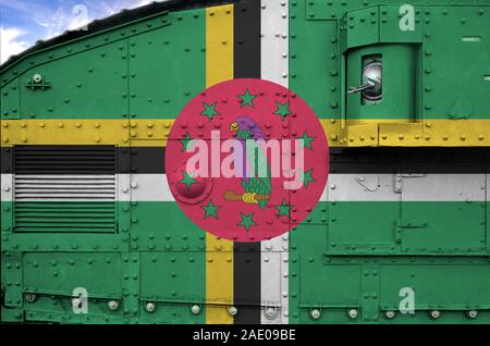 Dominica flag depicted on side part of military armored tank close up ...