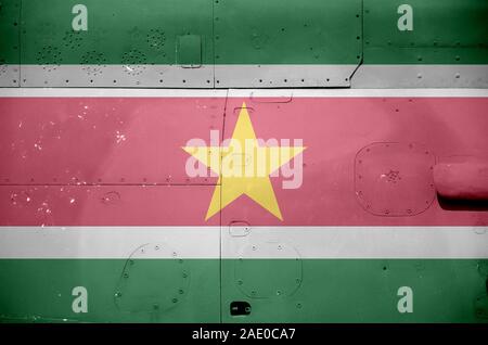 Suriname flag depicted on side part of military armored tank close up ...
