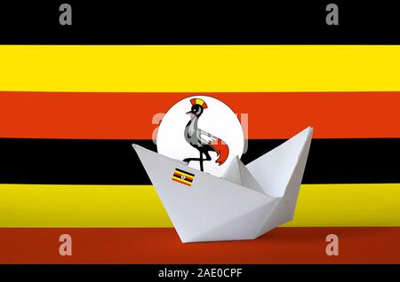 Uganda flag depicted on paper origami airplane. Oriental handmade arts ...