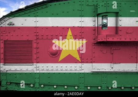 Suriname flag depicted on side part of military armored tank close up ...
