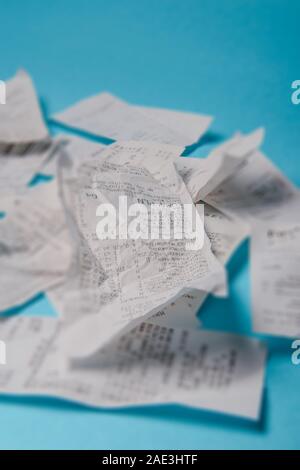 Pile of shopping receipts on a blue background Stock Photo - Alamy
