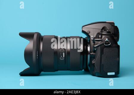 Professional modern DSLR camera against blue background Stock Photo - Alamy