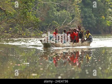 local villagers travelling by motorised dugout canoe Fly River, Papua ...