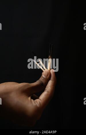 Hand holding an different extinguished matchstick Stock Photo - Alamy
