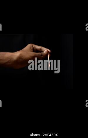 Hand holding an extinguished matchstick on black backgrounds Stock ...