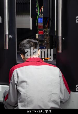 Industrial worker operate CNC fiber laser cutting machine Stock Photo ...