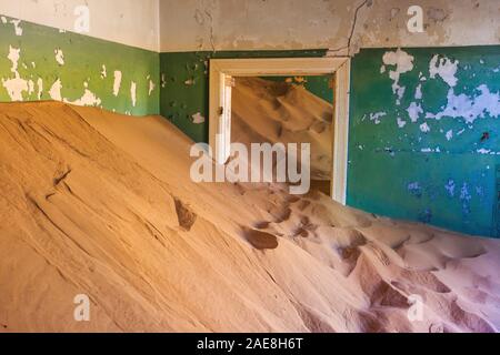 Abandoned and forgotten building and room being taken over by encroaching sandstorm, Kolmanskop ...