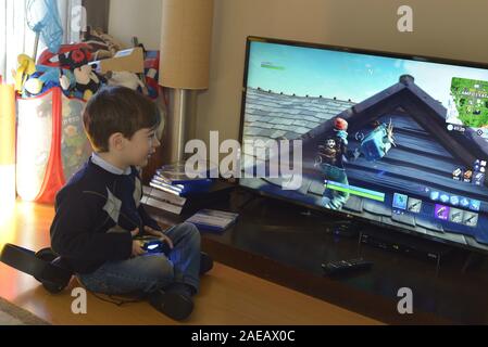 A child playing computer games with a PS4 Playstation four controller ...