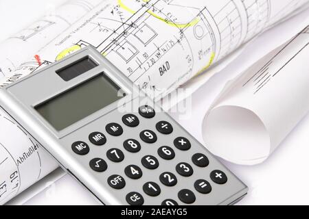 Bundled blueprints with calculator Stock Photo - Alamy