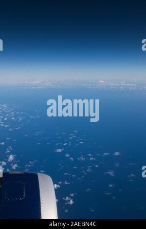 View of the Earth from the airplane flying above the clouds at high ...