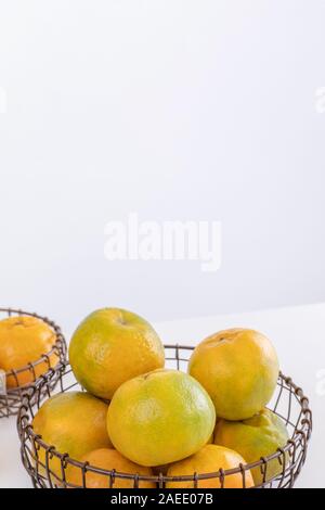 Beautiful peeled tangerines in a plate and metal basket isolated on ...