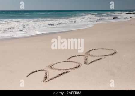Beach holiday with 2020 in the sand Stock Photo - Alamy
